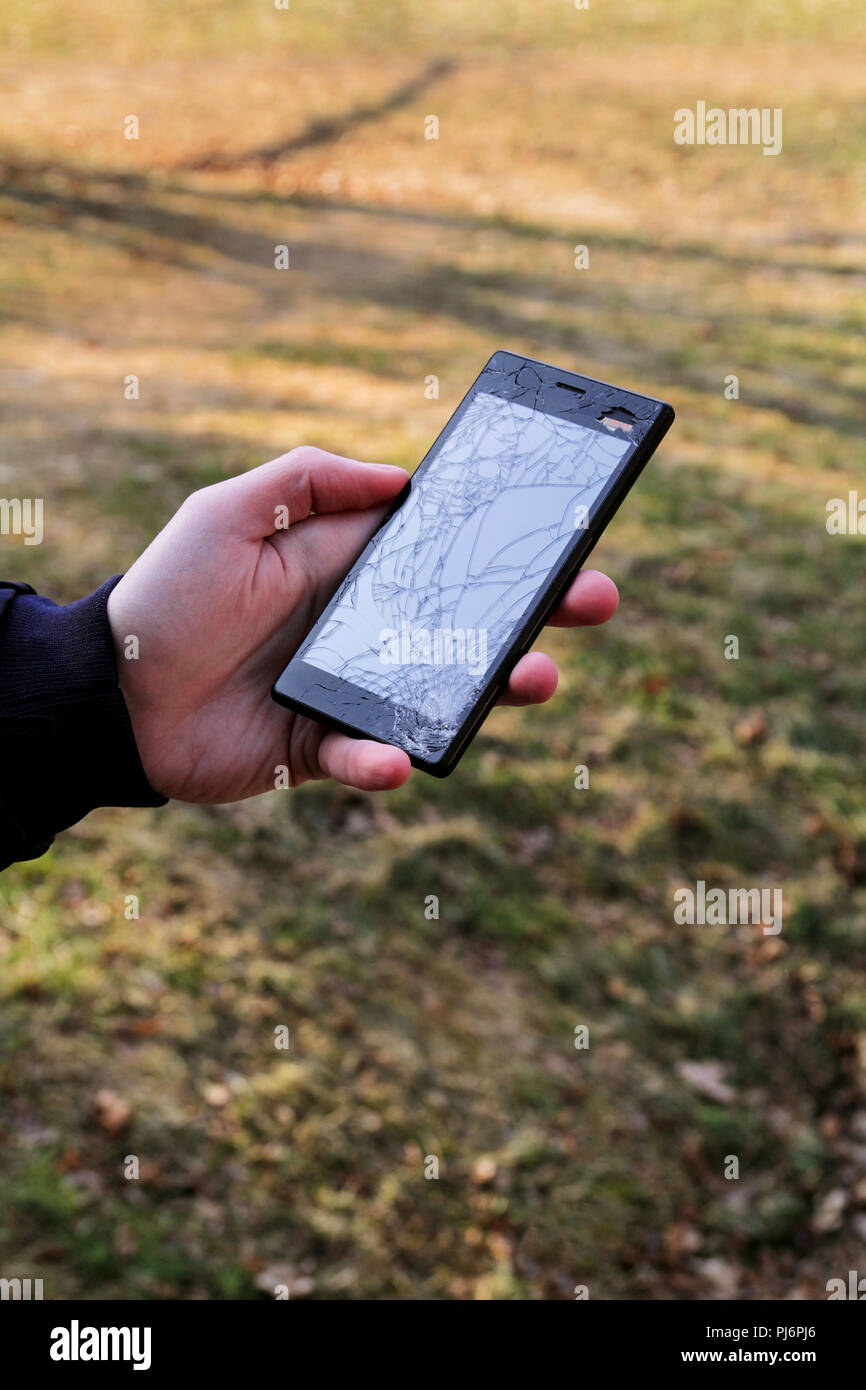 Human hand holding smart phone broken screen. Hand holding cracked ...