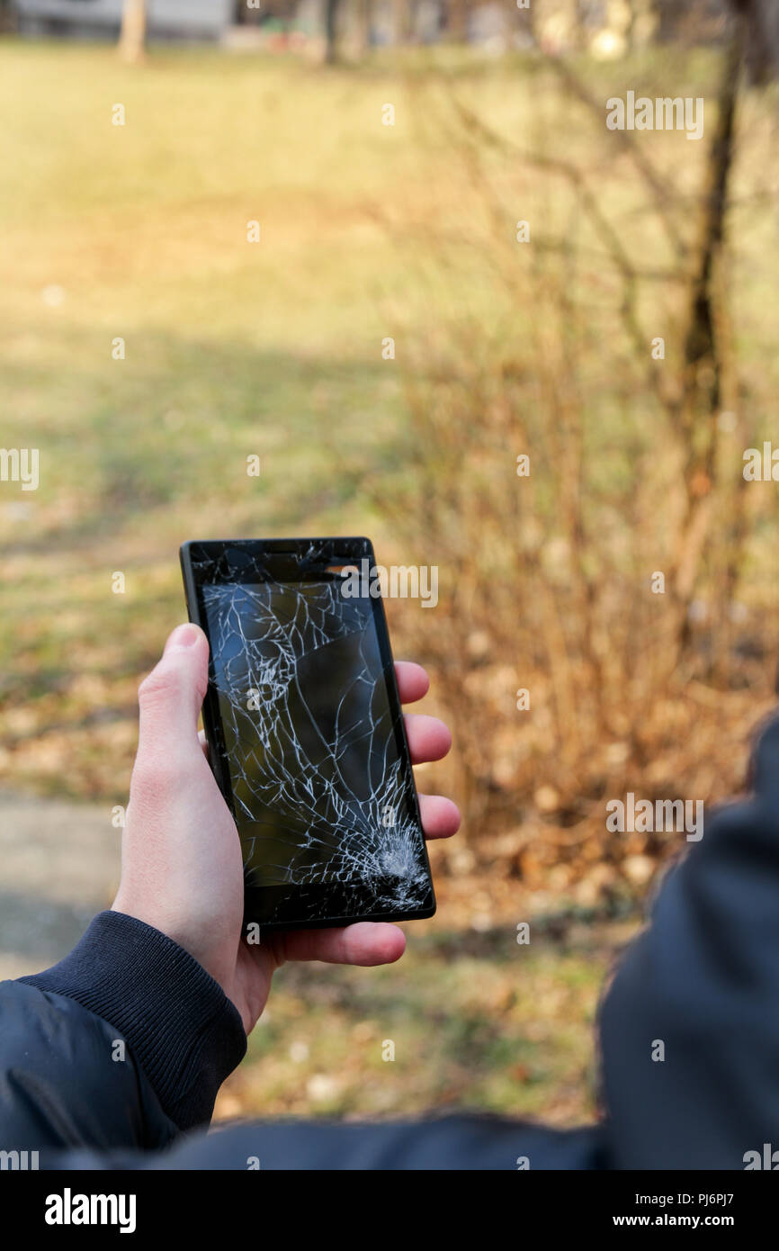 Human hand holding smart phone broken screen. Hand holding cracked ...