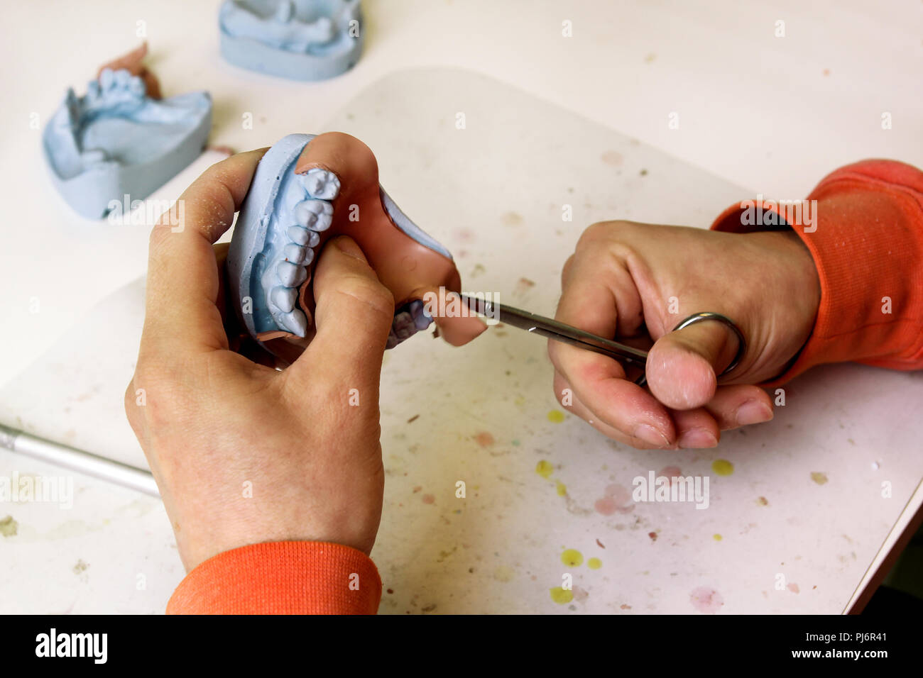Trimming with scissors Shellac base plates. Dentures. Dental prosthesis ...