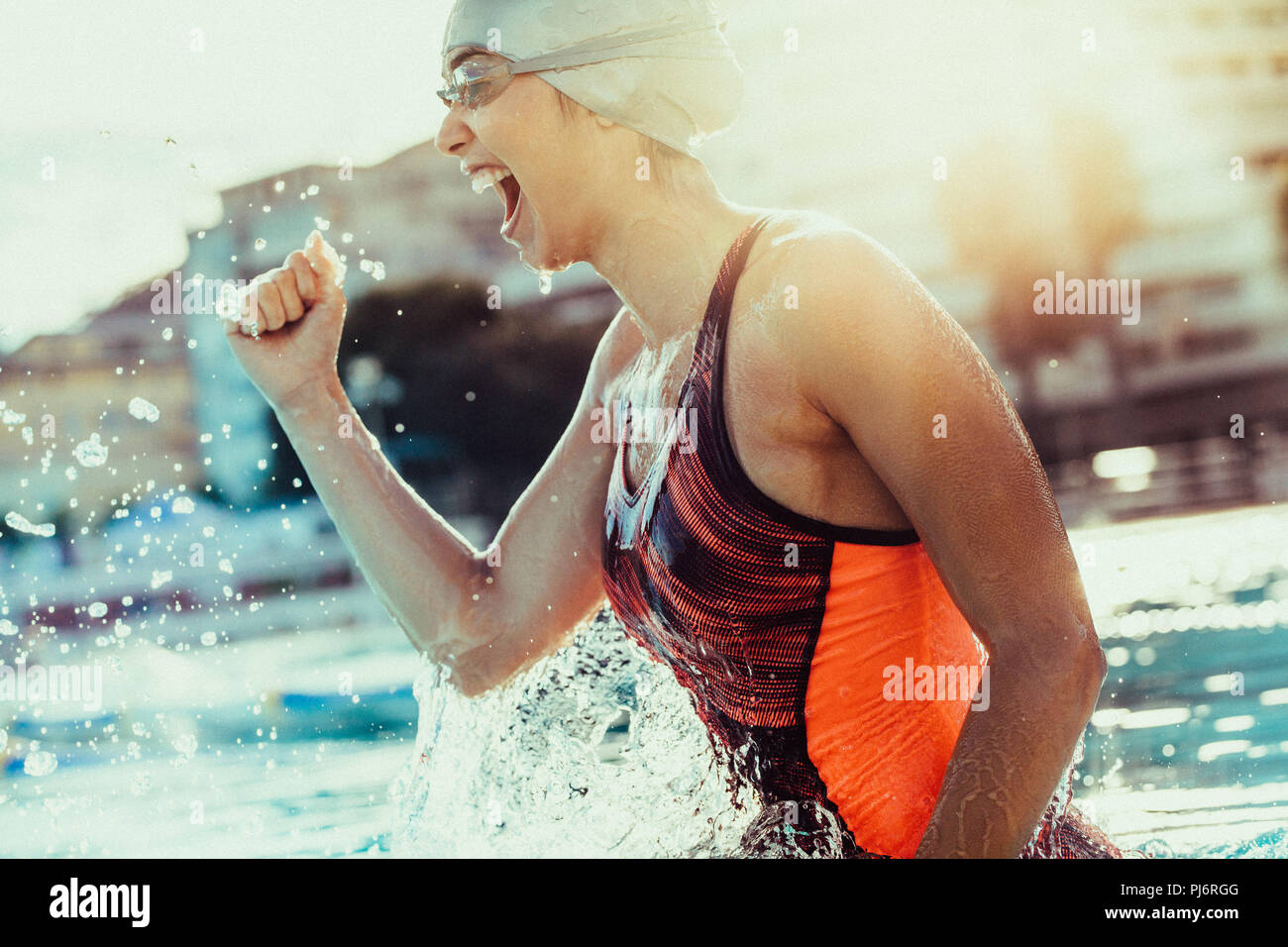 Excited female swimmer with clenched fist celebrating victory in the ...