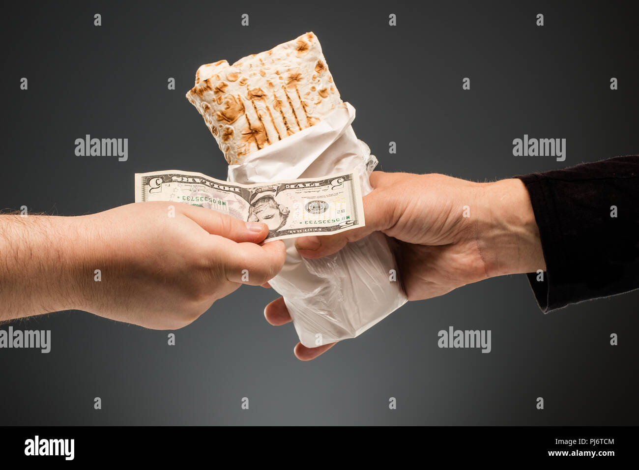 Hands exchange shawarma and dollars Stock Photo - Alamy