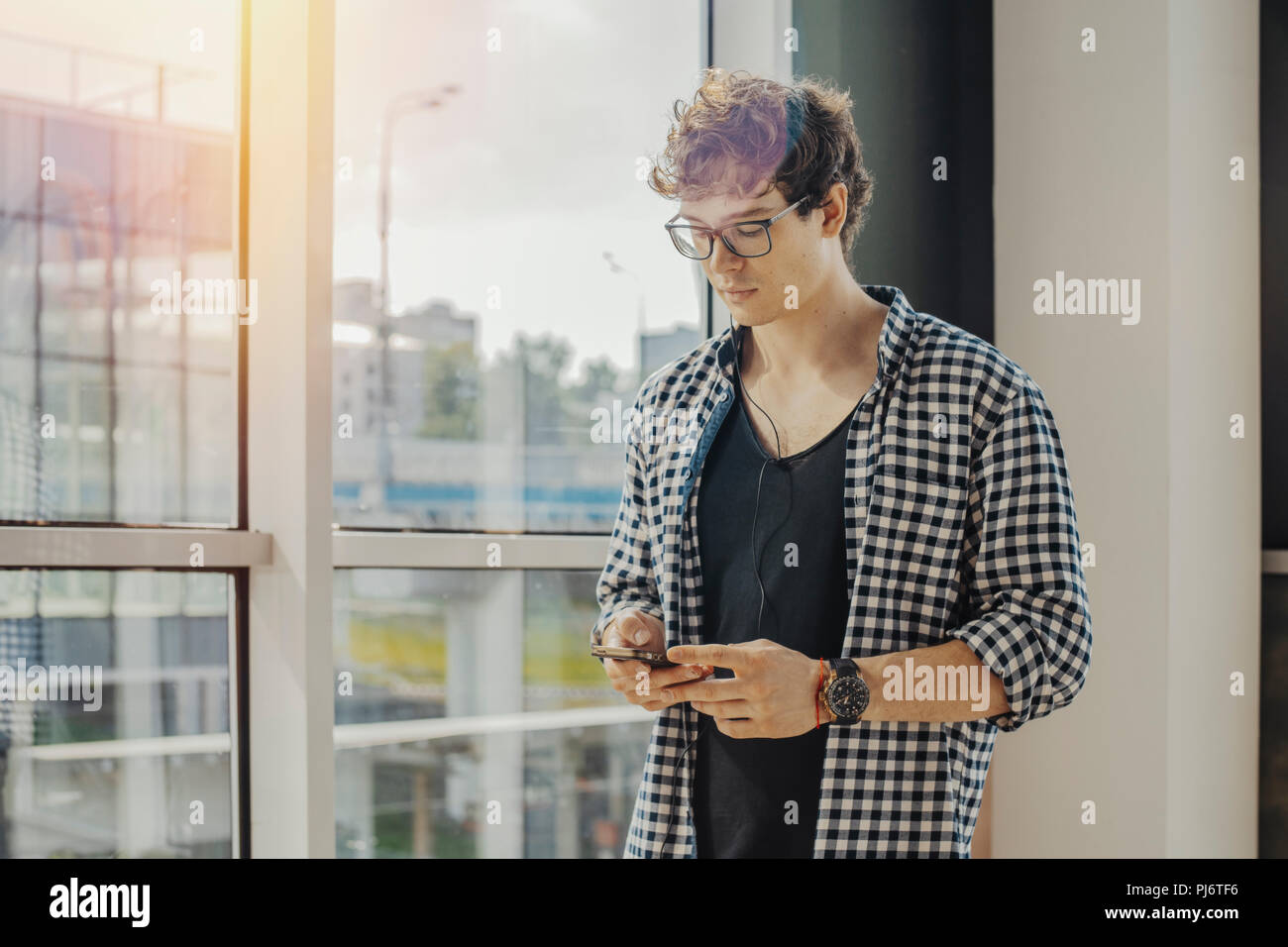 Close up of young man looking at mobile phone screen at metro station ...