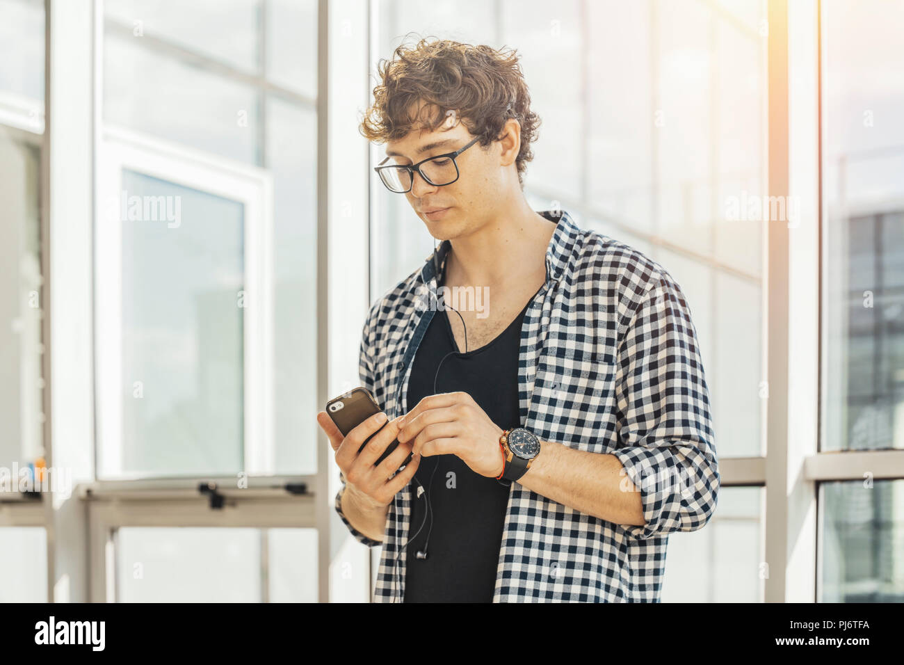 Close up of young man looking at mobile phone screen at metro station ...