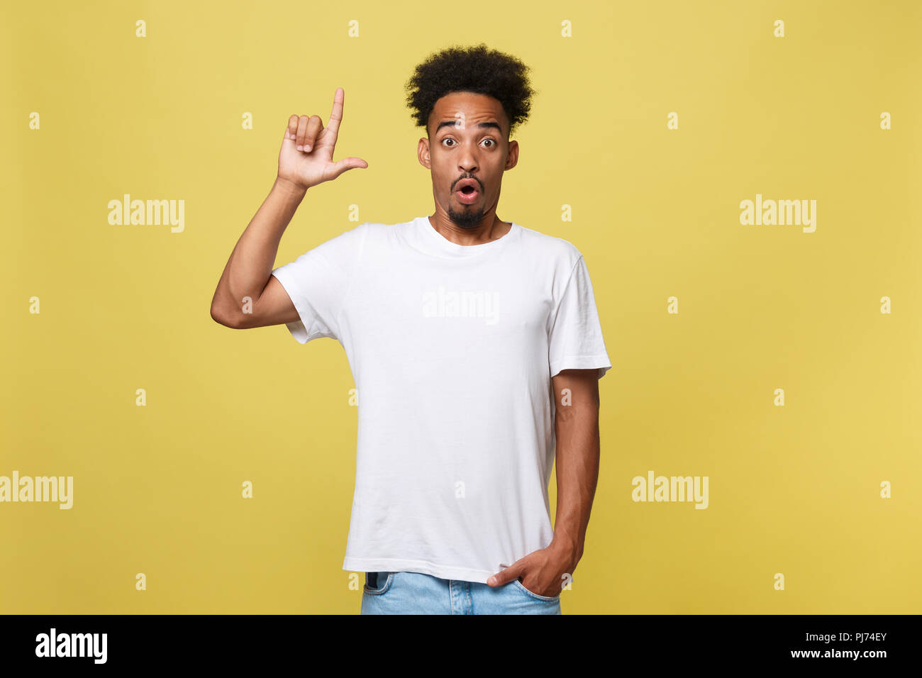 Astonished young African American man dressed in casual white shirt ...