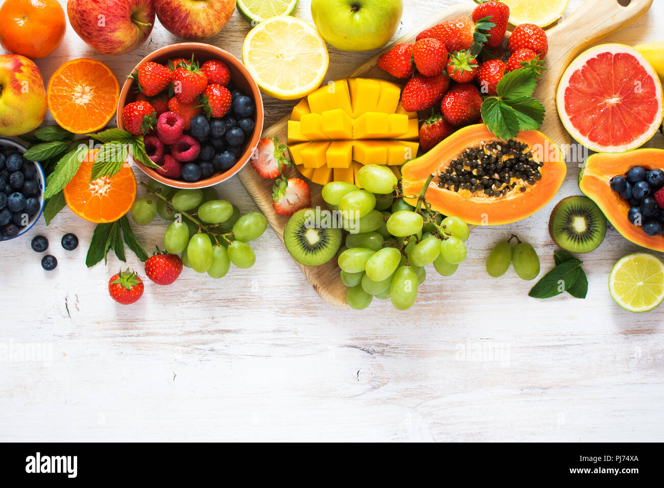 Overhead view of rainbow colored fruits, strawberries, blueberries ...