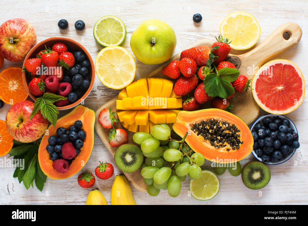 Different rainbow colored fruits, strawberries, blueberries, mango ...