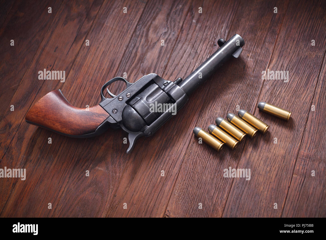Old revolver with cartridges on wooden table Stock Photo - Alamy