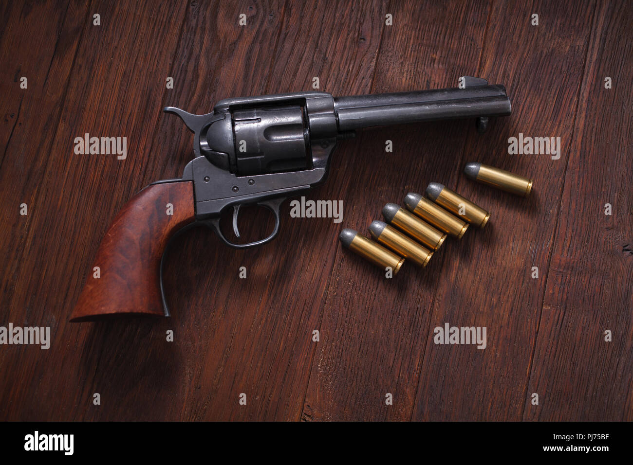 Old revolver with cartridges on wooden table Stock Photo - Alamy