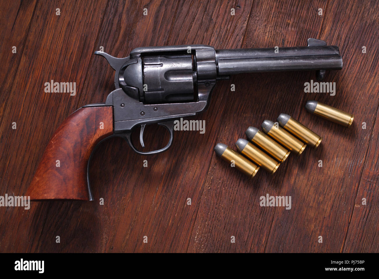 Old revolver with cartridges on wooden table Stock Photo - Alamy