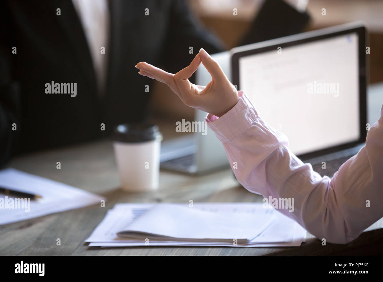Worker meditating at workplace in front of laptop Stock Photo - Alamy
