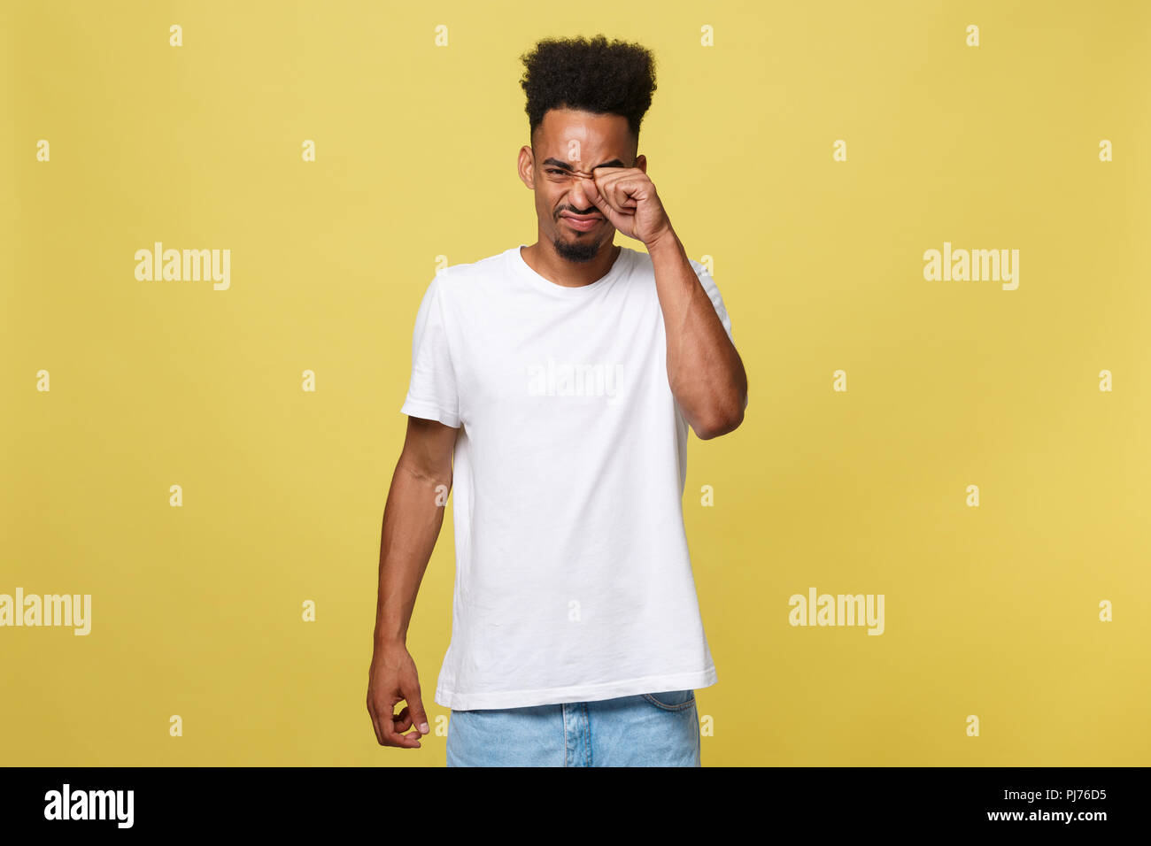 Closeup portrait man with sad expression, isolated on yellow wall ...