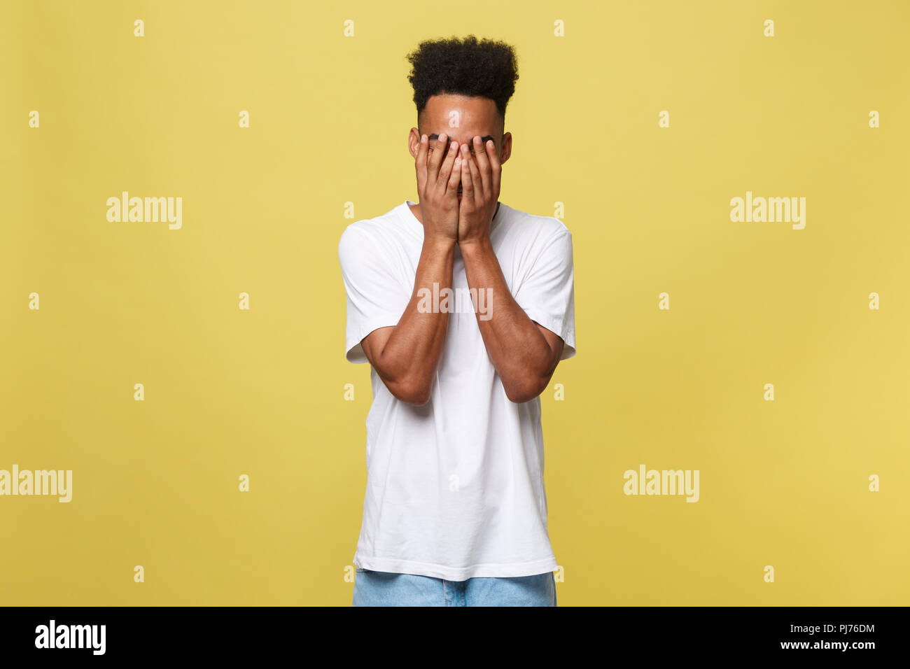 Closeup portrait man with sad expression, isolated on yellow wall ...