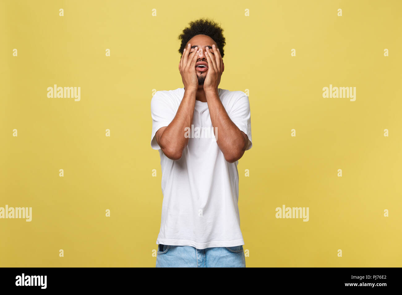 Closeup portrait man with sad expression, isolated on yellow wall ...