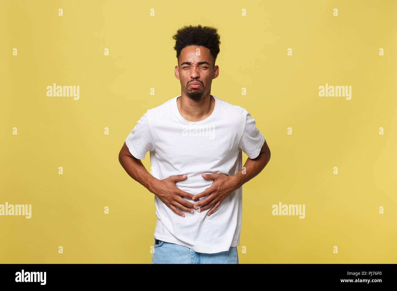 Closeup portrait of miserable, upset, young man, doubling over in ...