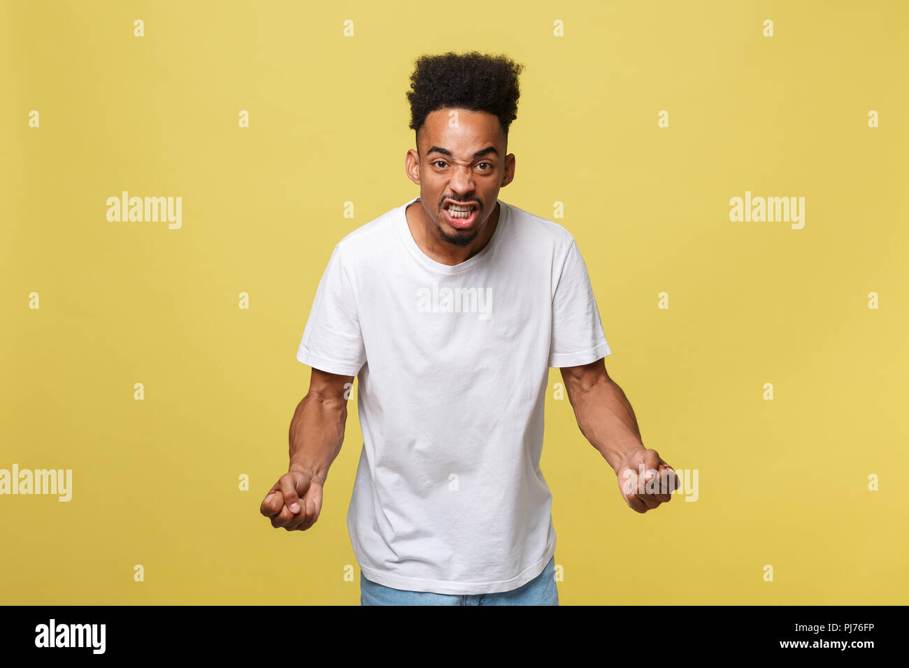 Portrait of angry or annoyed young African American man in white shirt ...