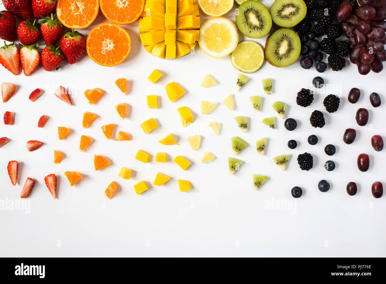 Top view of whole fruits and cut slices in the rows; red, orange ...