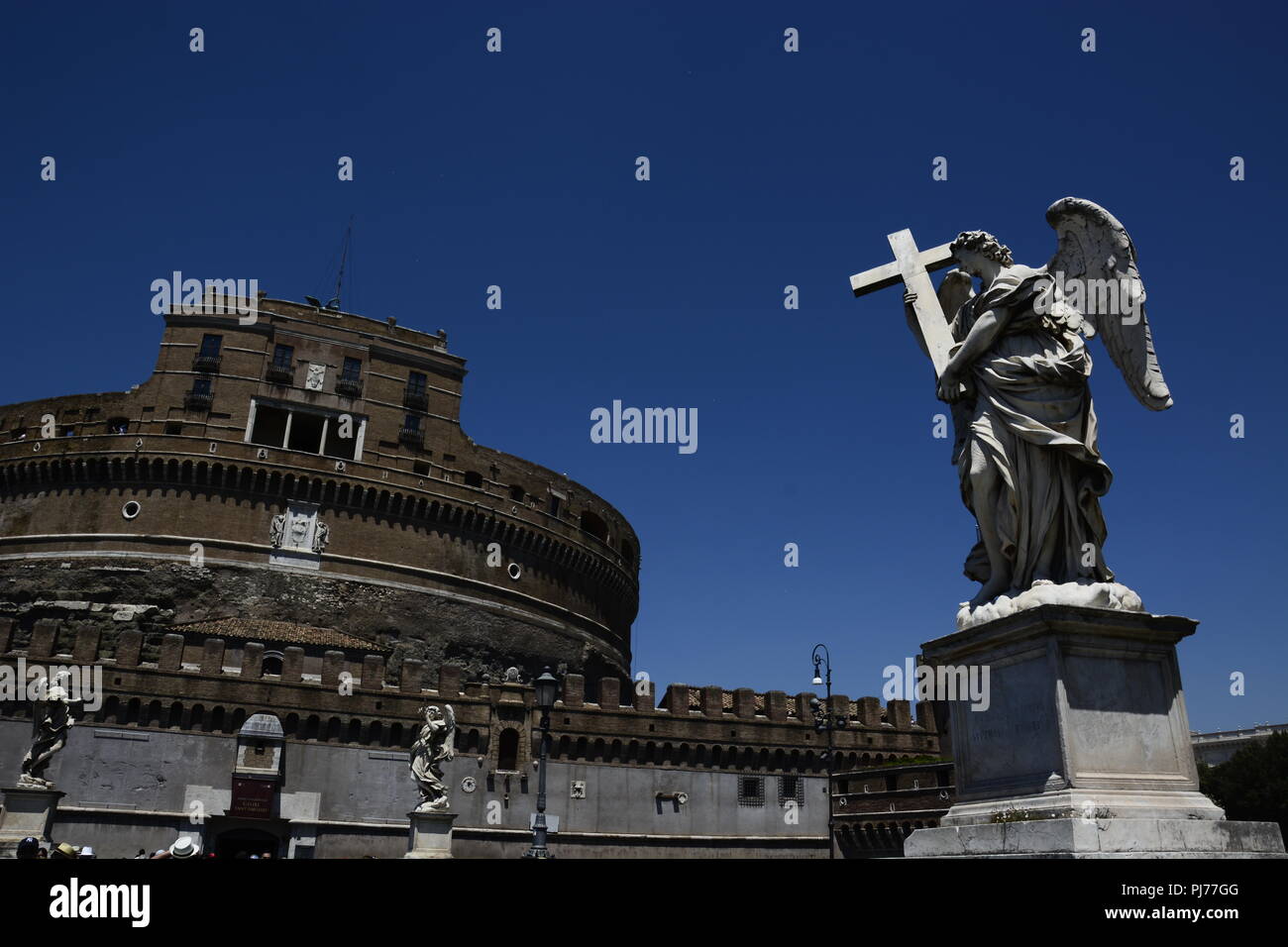 angel holding a cross in front of castel san angelo in rome with a deep ...