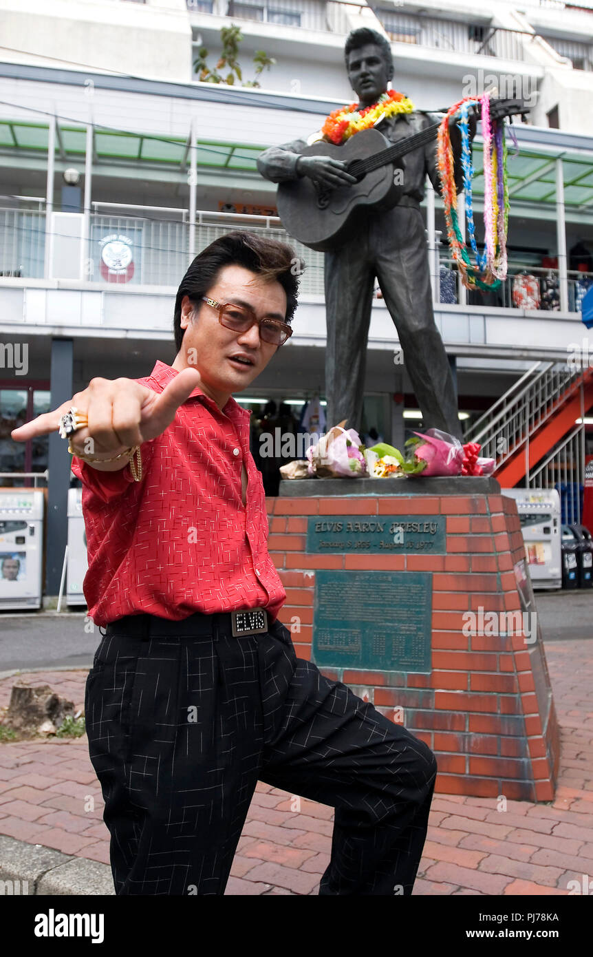 Elvis Presley impersonator Aaron Narikiyo stands by a commemorative ...