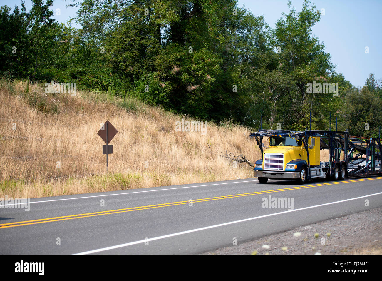 Specialized empty yellow big rig car hauler semi truck with two-tiered ...