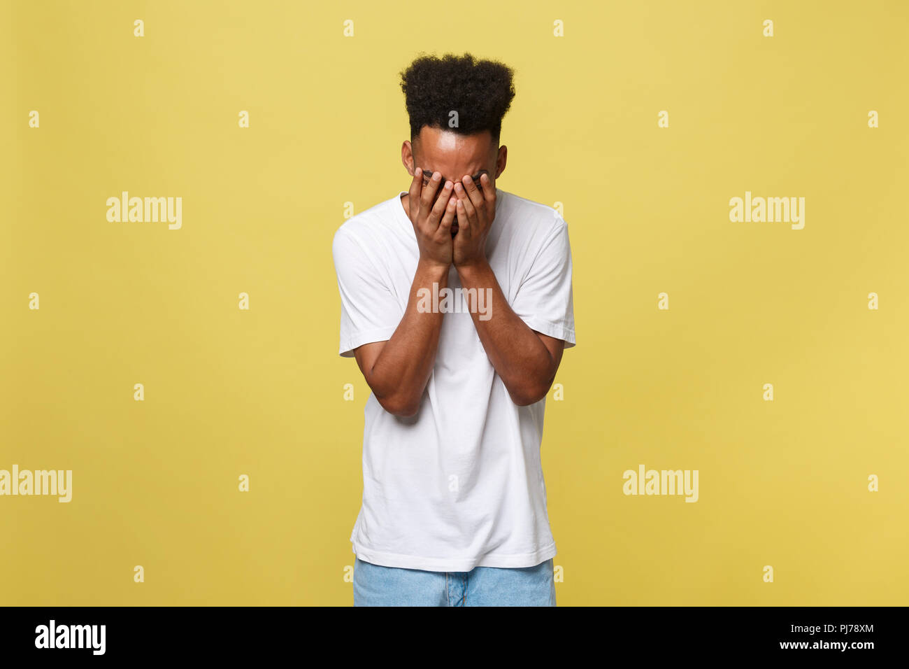 Closeup portrait man with sad expression, isolated on yellow wall ...