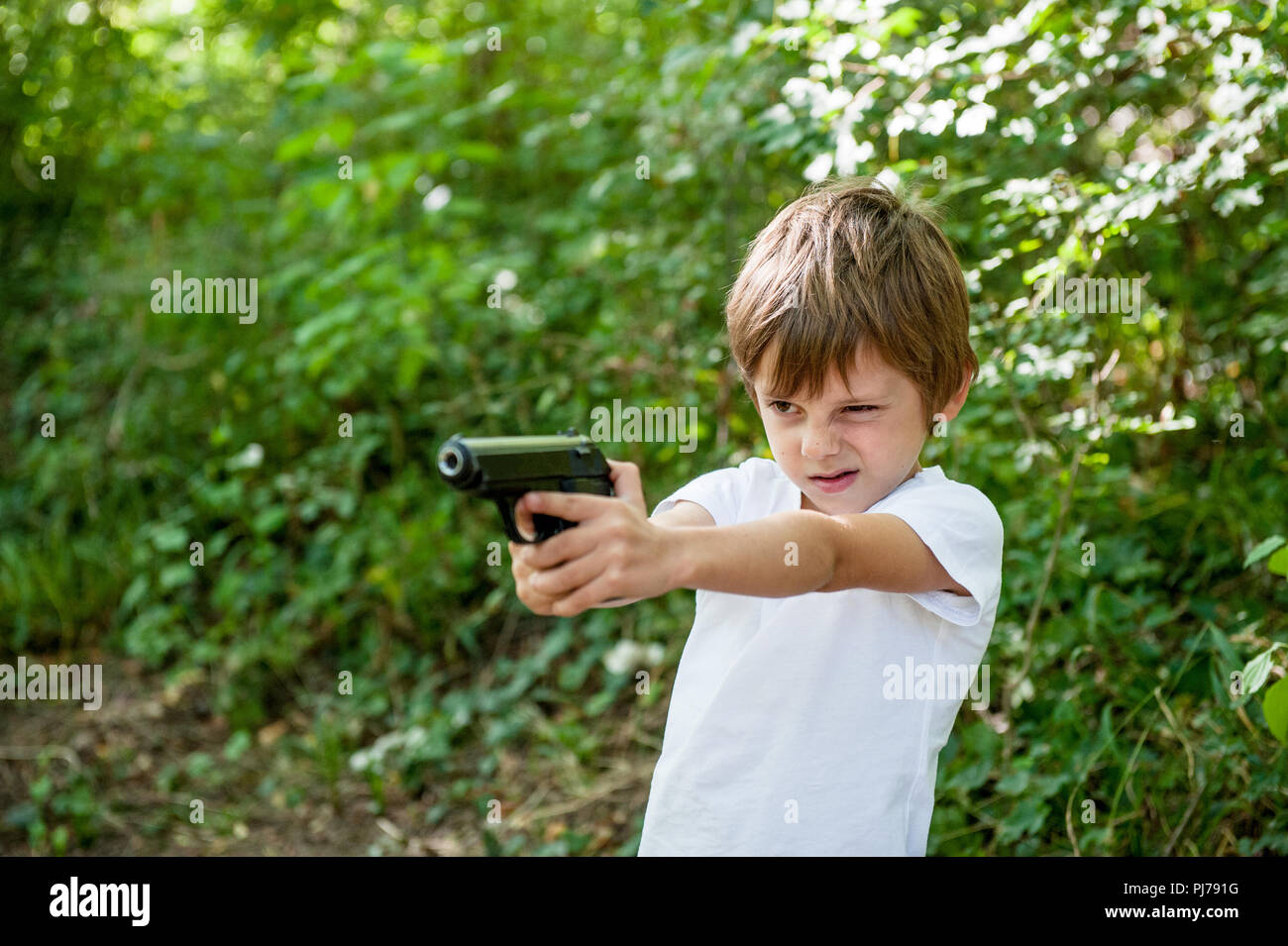 little kid sniper point gun in target carefully aiming outdoors on ...