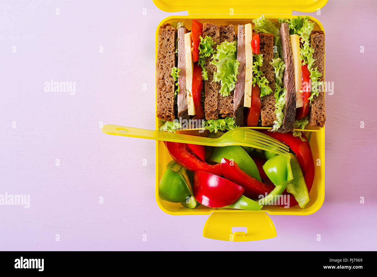 Healthy school lunch box with beef sandwich and fresh vegetables on ...