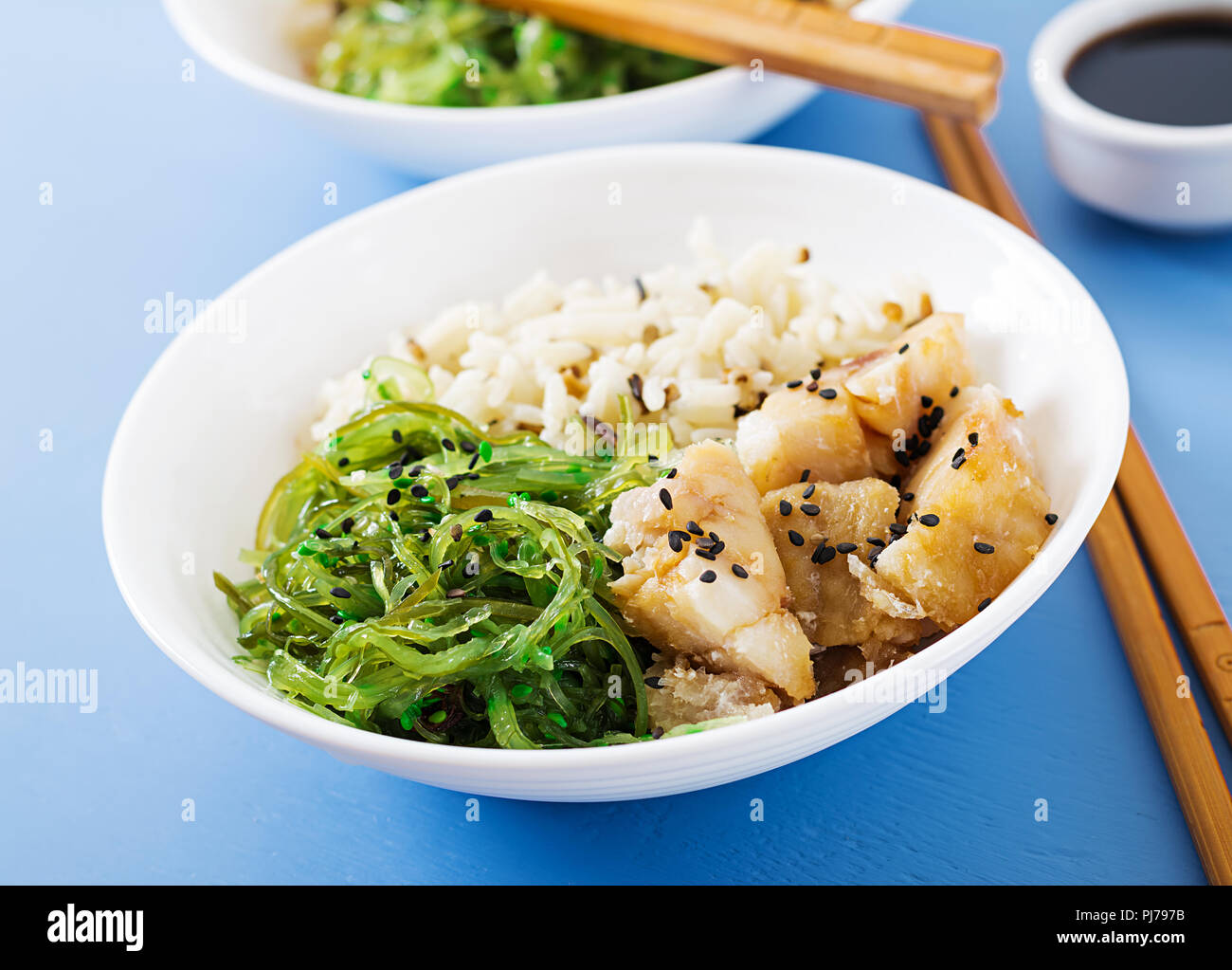Japanese food. Bowl of rice, boiled white fish and wakame chuka or ...