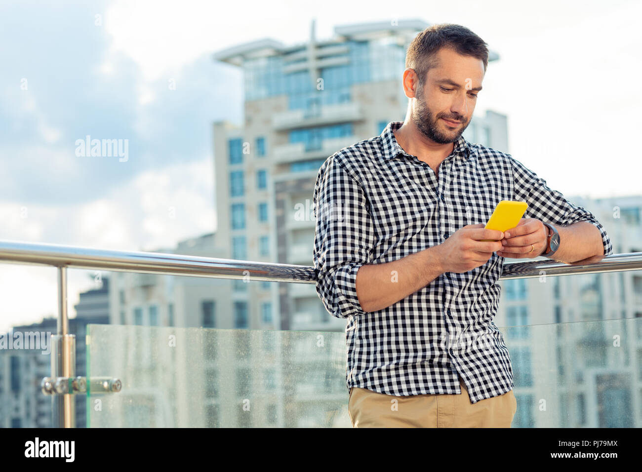 Positive handsome man looking at his smartphone screen Stock Photo - Alamy