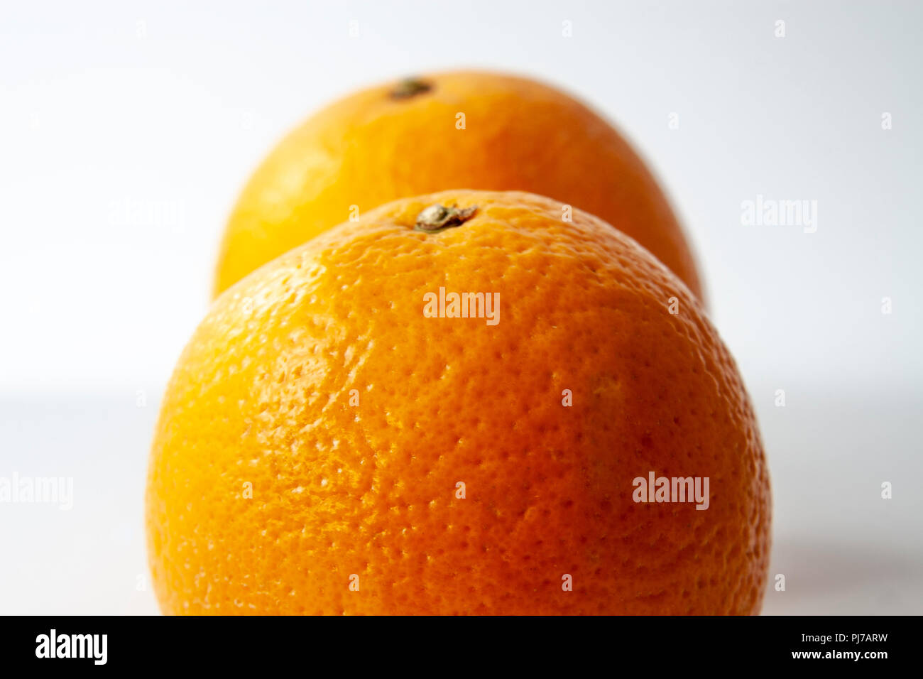 Two oranges placed behind each other isolated on white background ...