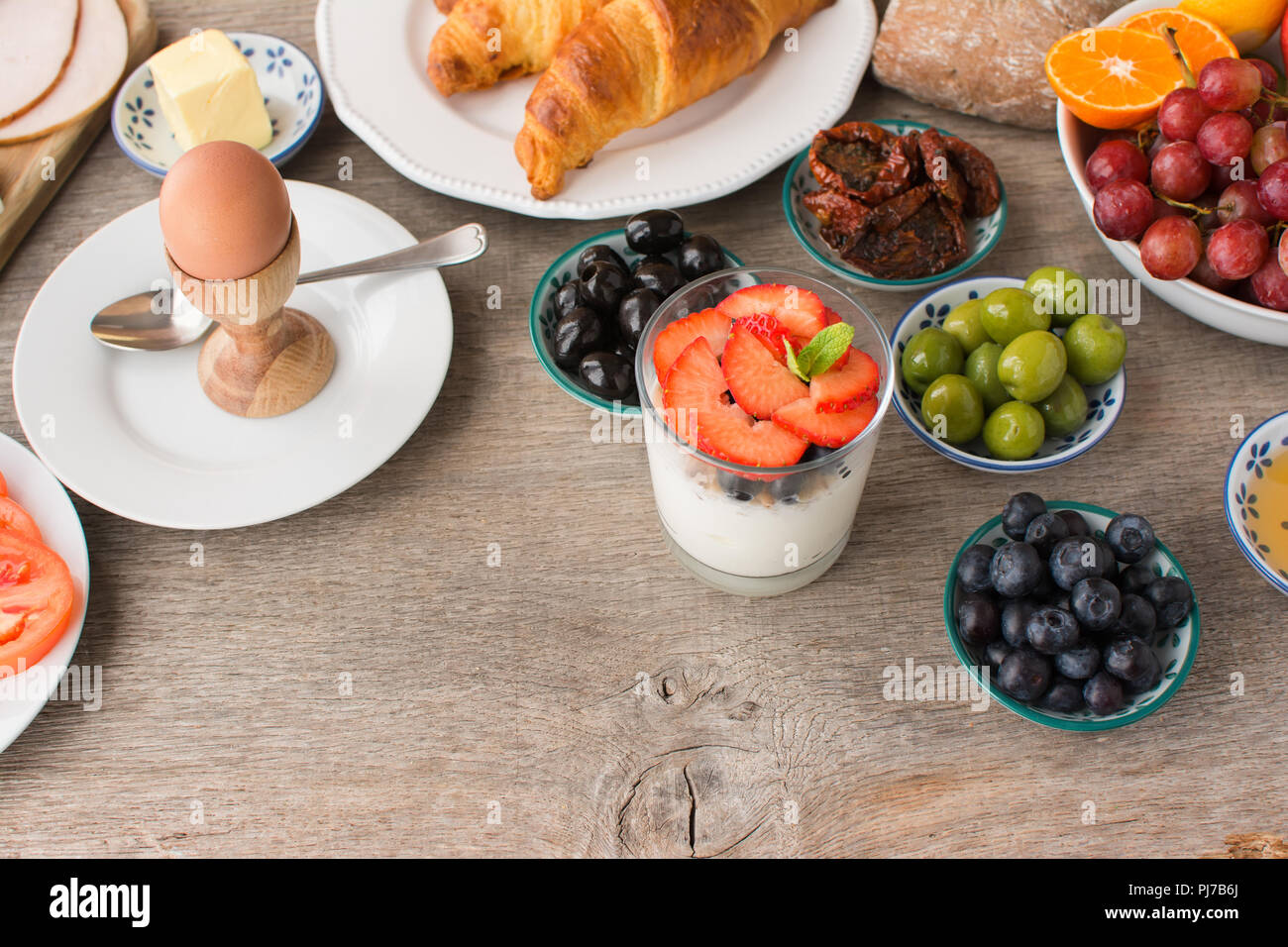 Healthy breakfast selection: yogurt with nuts and berries, with olives ...