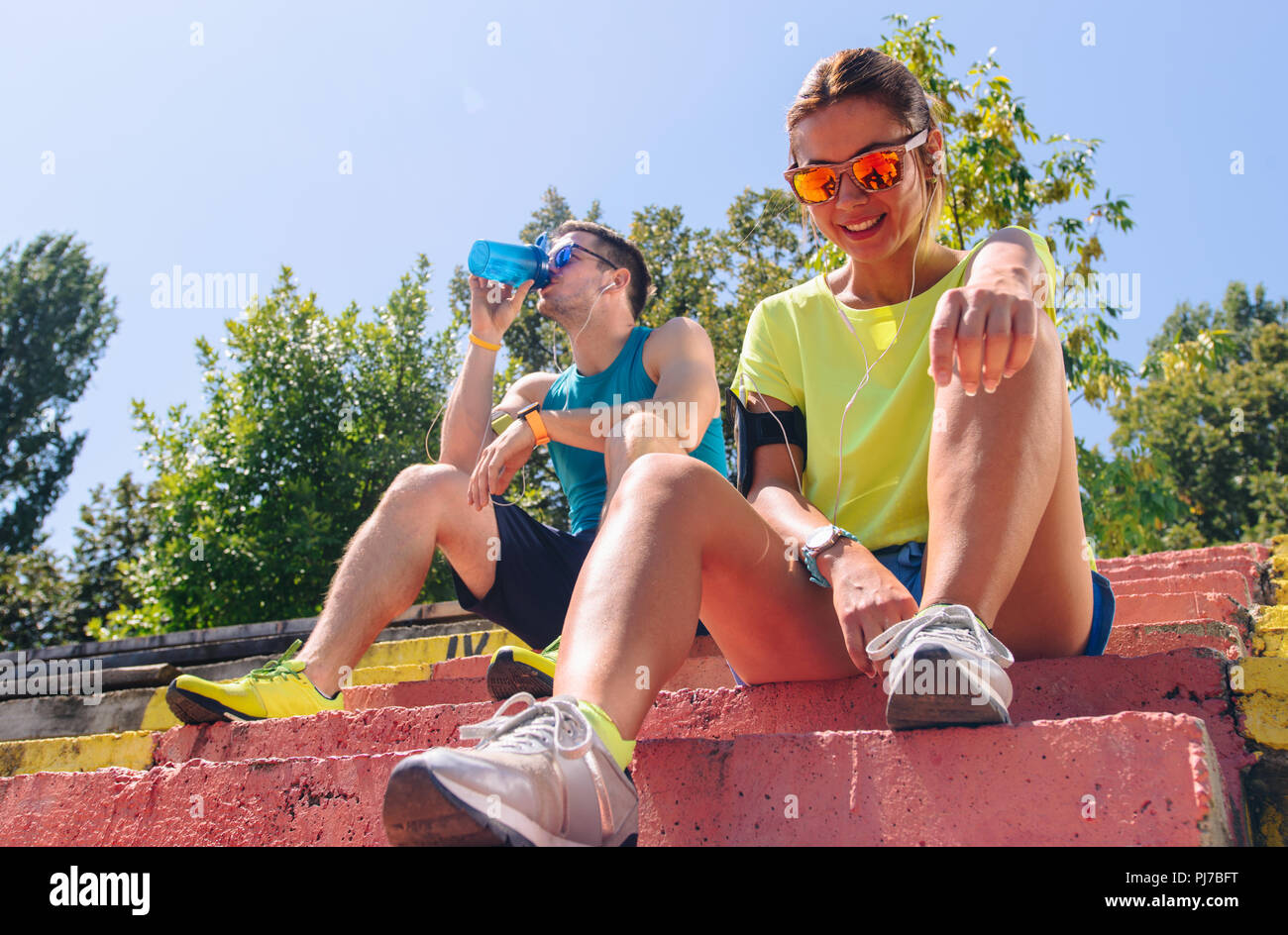 Runners resting taking a break drinking water after running outside ...