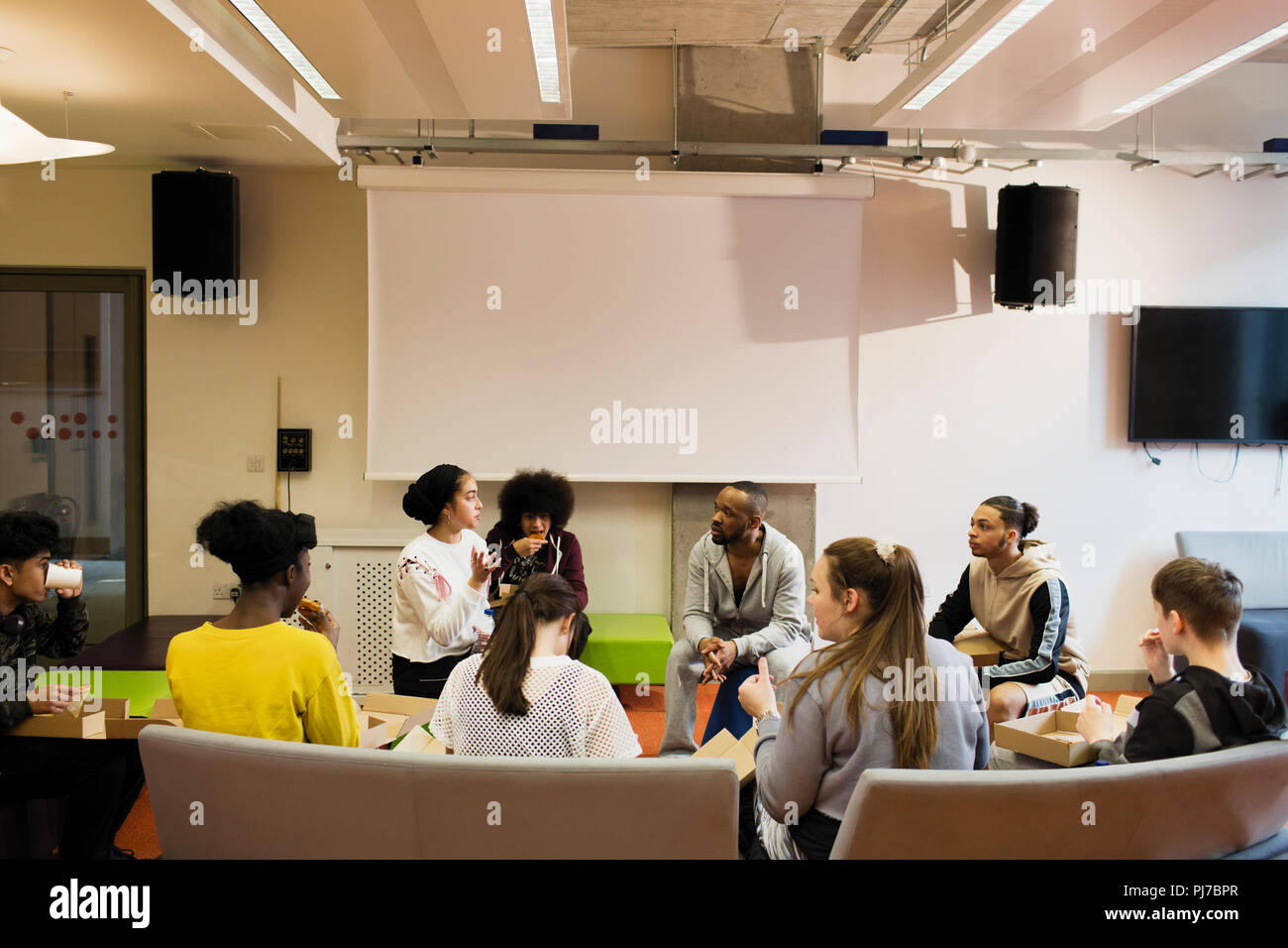 Teenagers and mentor talking in community center Stock Photo - Alamy