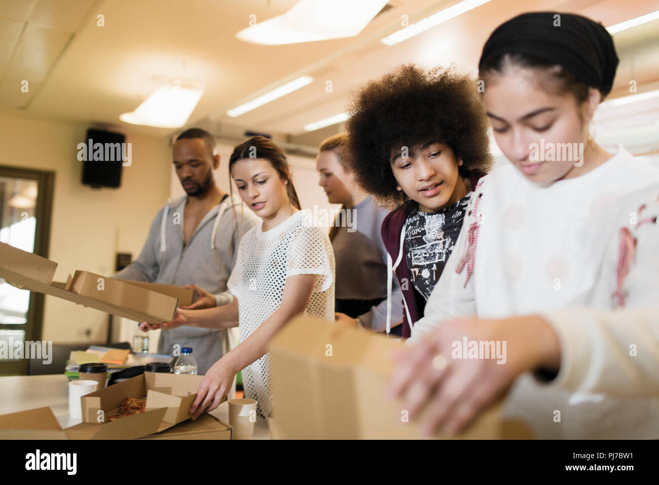 Teenagers eating pizza in community center Stock Photo - Alamy
