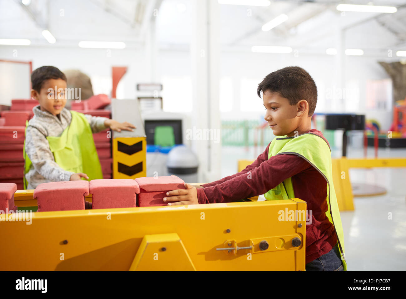 Boy playing at interactive construction exhibit in science center Stock ...