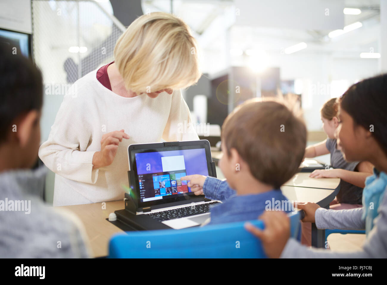Teacher and students using laptop in science center Stock Photo - Alamy
