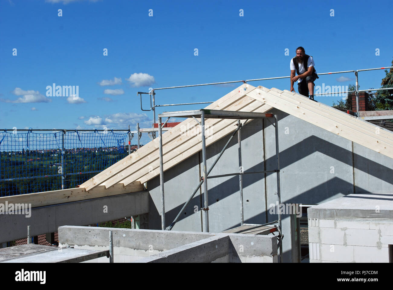 A German 'Master' carpenter wearing traditional work clothing surveys ...