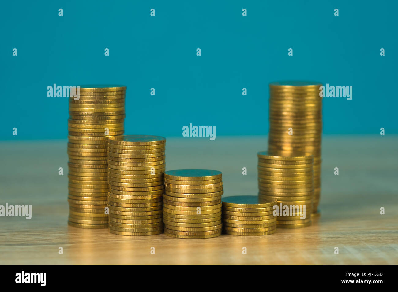 Increasing columns of coins, step of coins stacks on wooden table with ...