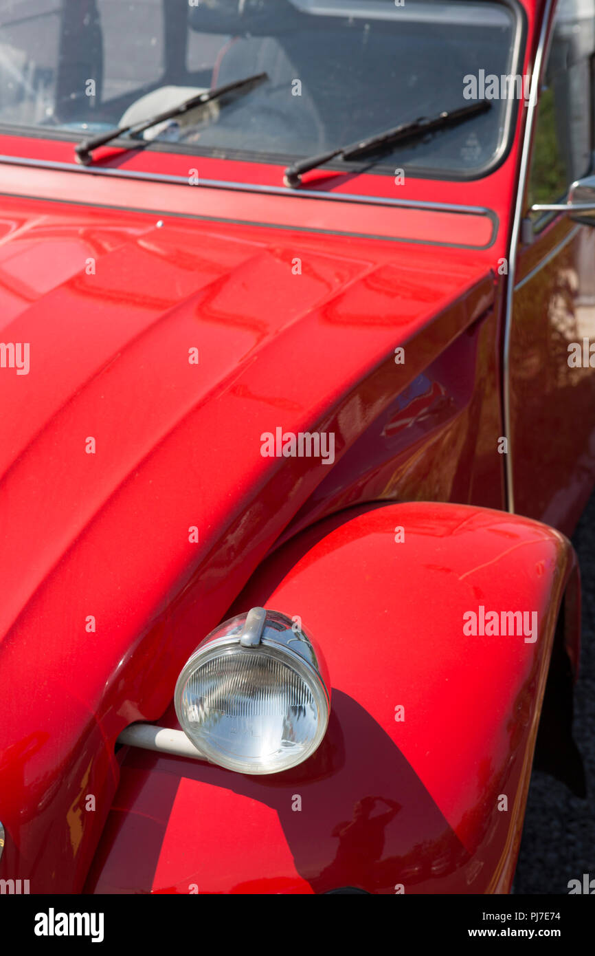 Detail of an old red Citroen 2CV car set aginst a deep blue summer sky ...