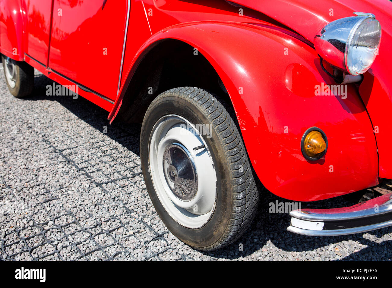 Detail of an old red Citroen 2CV car set aginst a deep blue summer sky ...