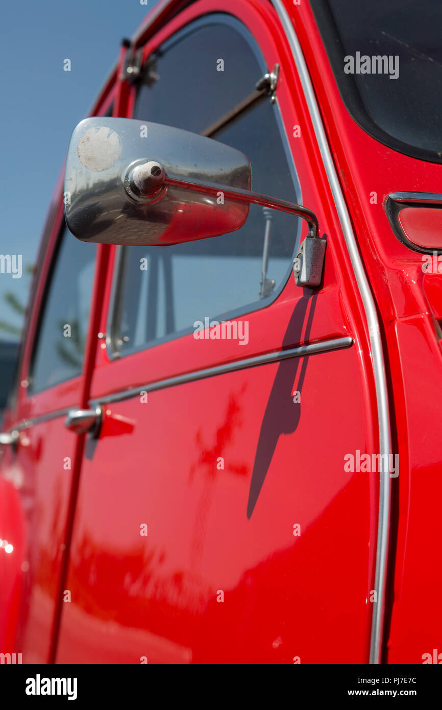 Detail of an old red Citroen 2CV car set aginst a deep blue summer sky ...
