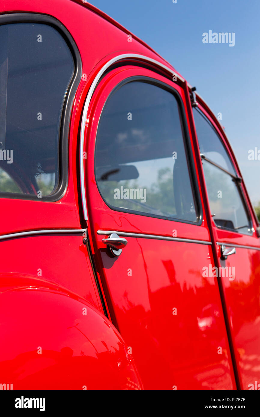 Detail of an old red Citroen 2CV car set aginst a deep blue summer sky ...