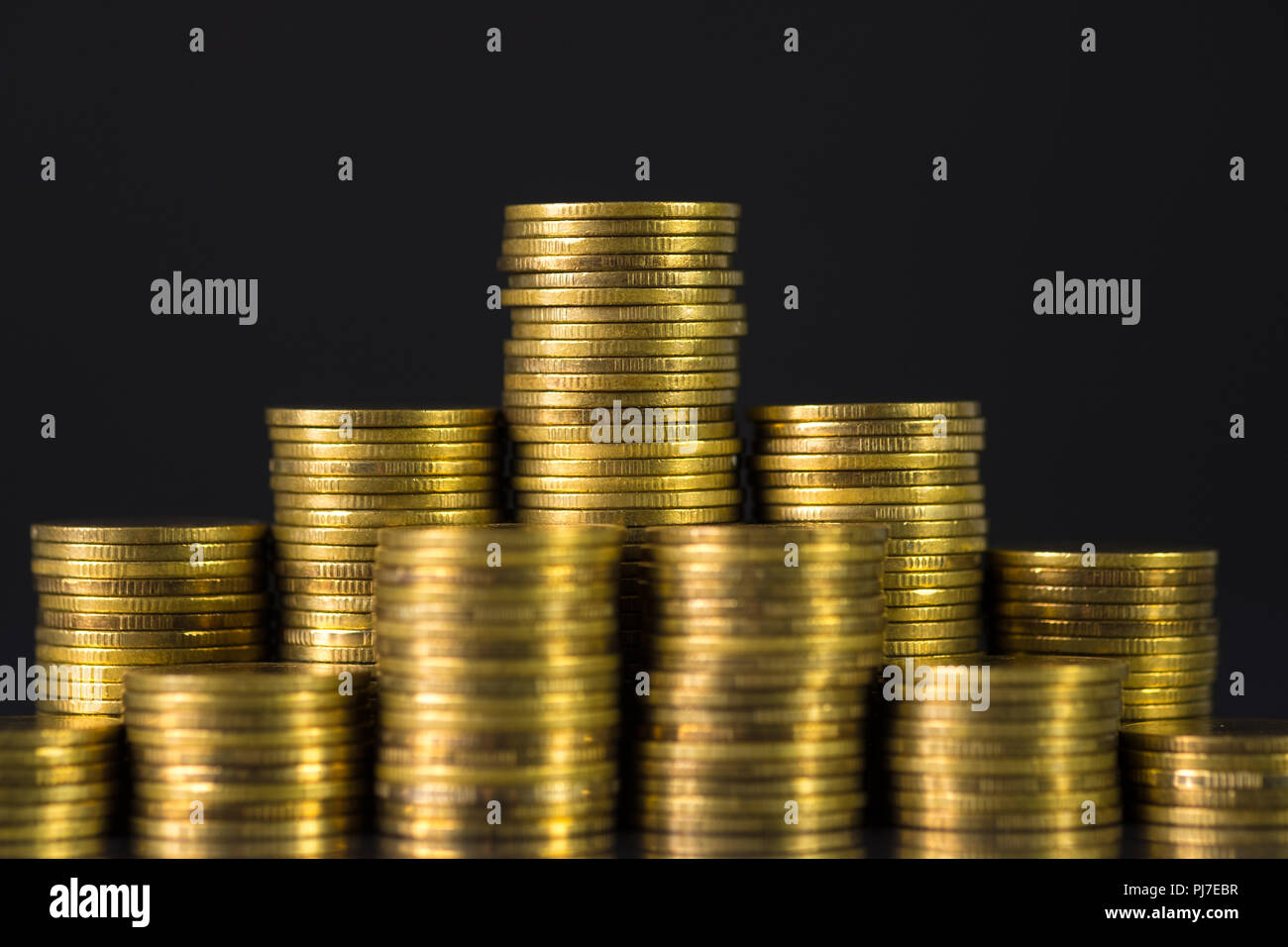 Increasing columns of coins, step of stacks coin on dark background ...