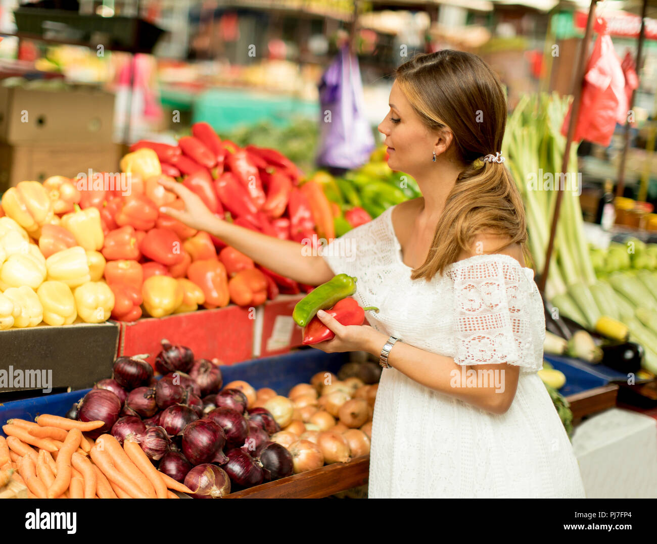 Pretty young woman buying fresh vegetables on the market Stock Photo ...