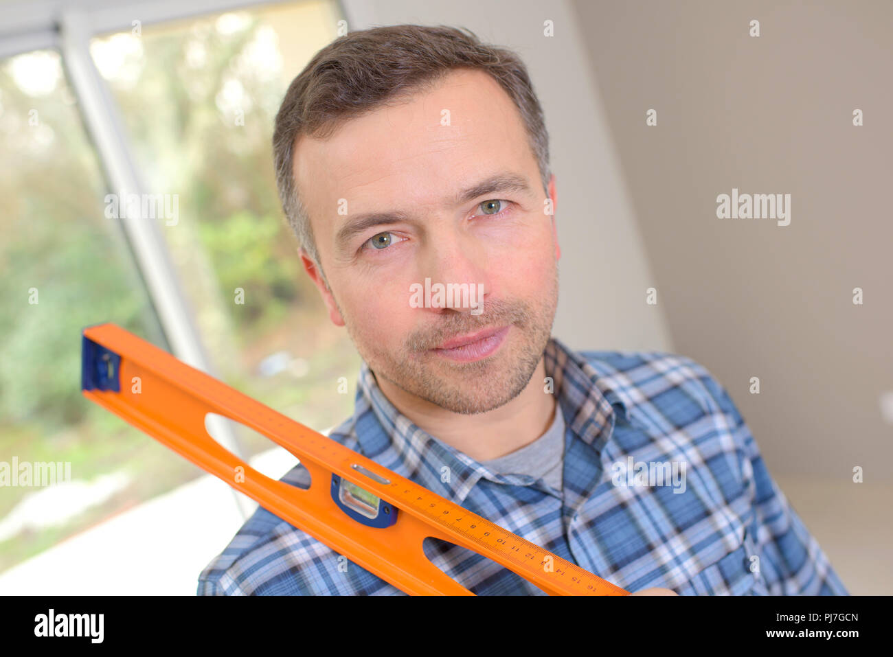 Builder using a spirit level Stock Photo - Alamy
