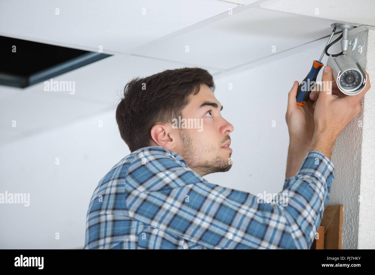 Man fitting security camera Stock Photo - Alamy