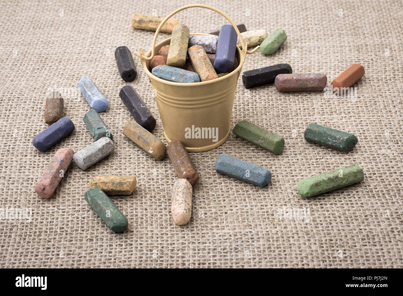 Crayons of various color in a bucket on a canvas Stock Photo - Alamy