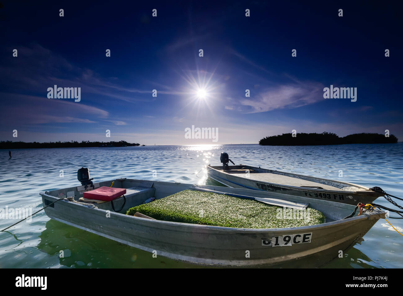 Sun rising over two anchored Skiffs in Cow Key Channel in Key West ...