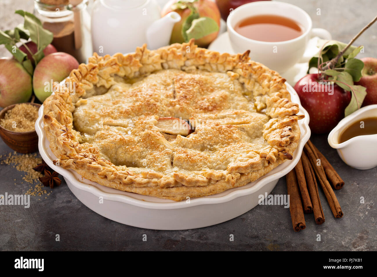 Homemade apple pie with leaves cut outs served with tea and caramel ...
