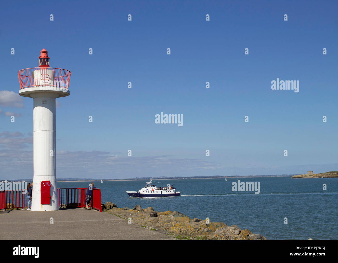 People standing beside the lighthouse in Howth, Dublin,Ireland ...