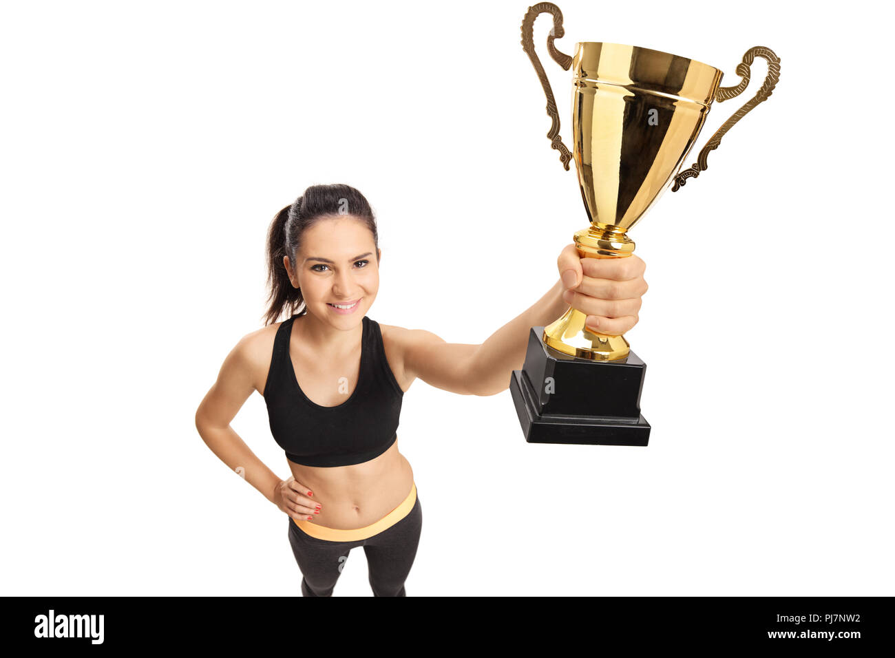 Young female in sportswear holding a gold trophy cup isolated on white ...